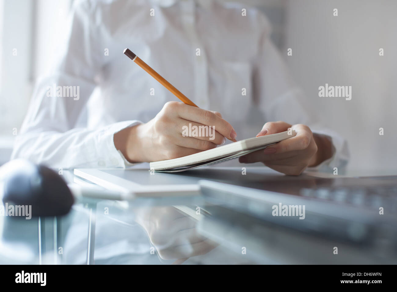 Woman's hand using a pencil noting on notepad Stock Photo - Alamy
