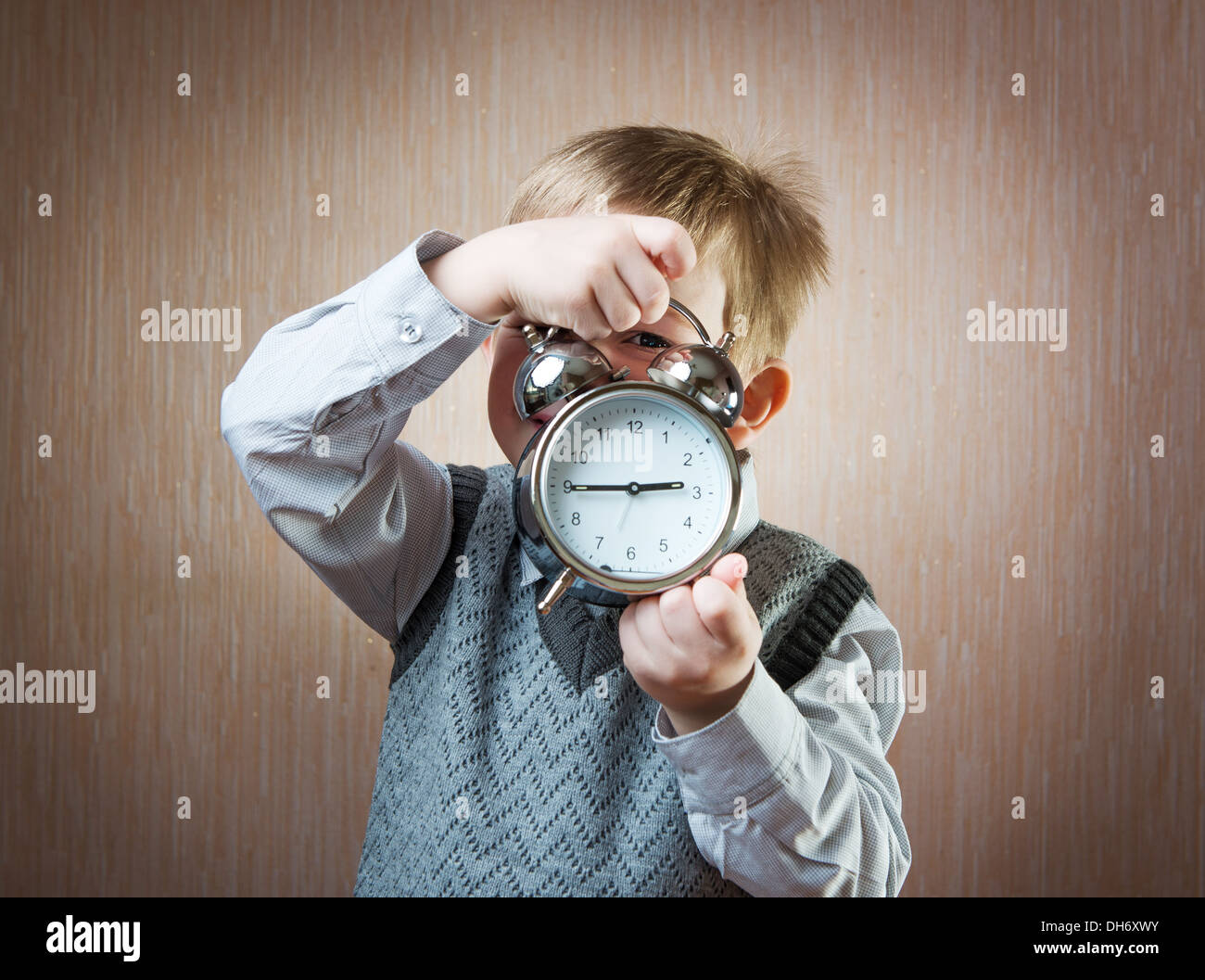 Portrait of cute diligent boy holding alarm clock Stock Photo - Alamy