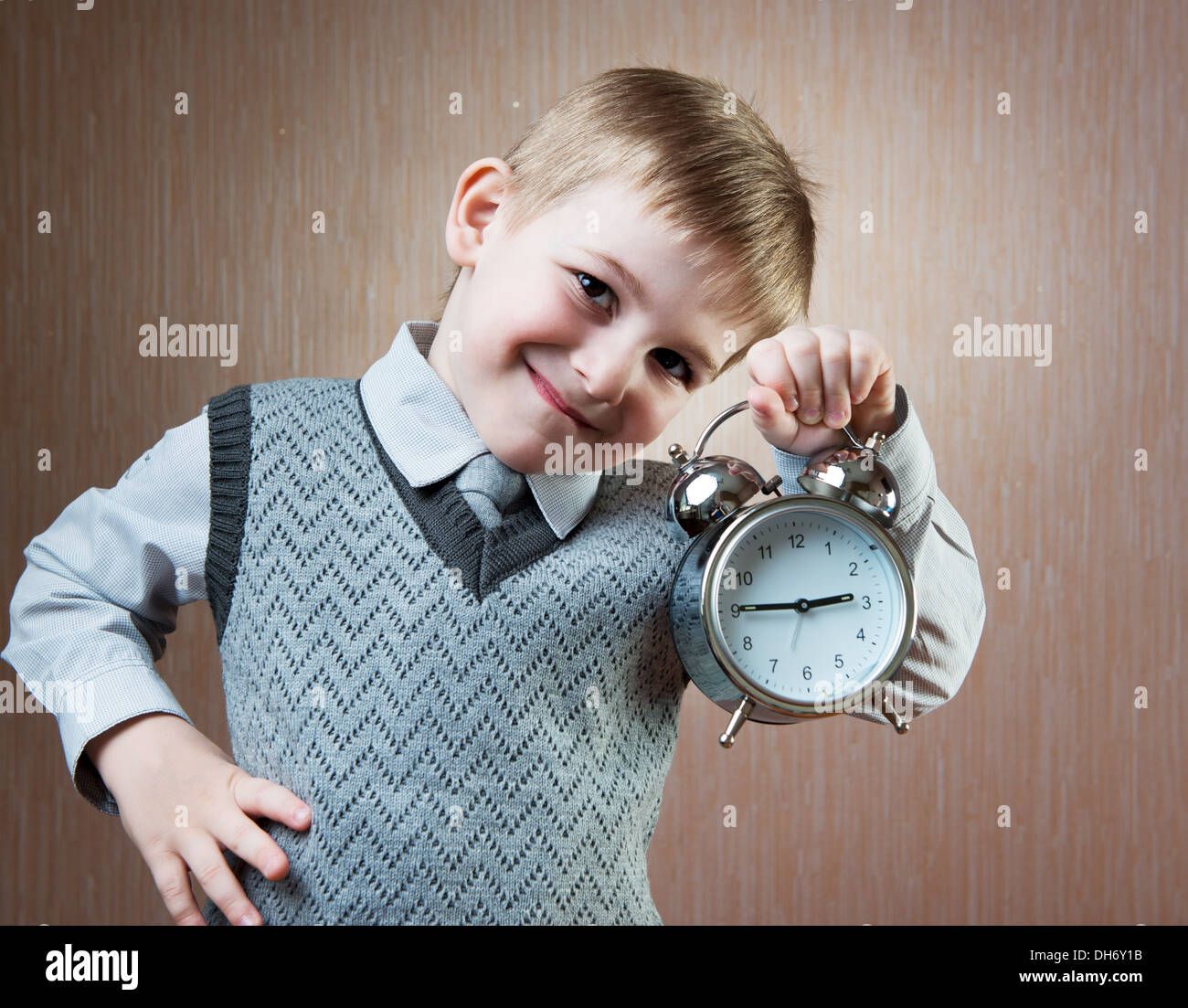 Portrait of cute diligent boy holding alarm clock Stock Photo - Alamy