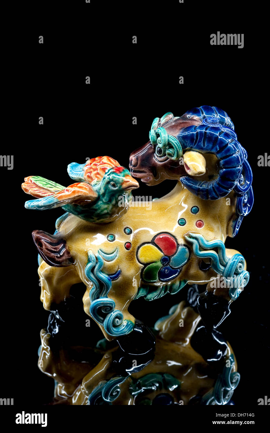Traditional sculpture of Chinese zodiac sign, Goat carrying a bird ...