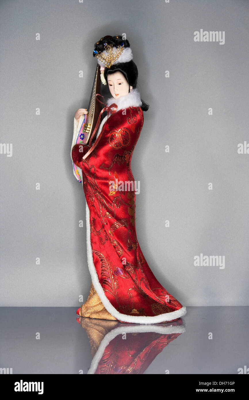 Beijing silk doll in ancient embroidered red clothes, holding Chinese ...