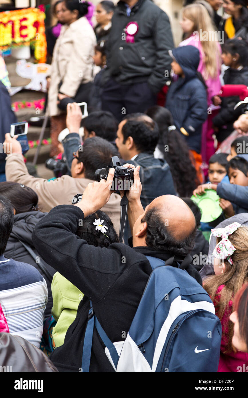 People using digital cameras and mobile phones to photograph a ...