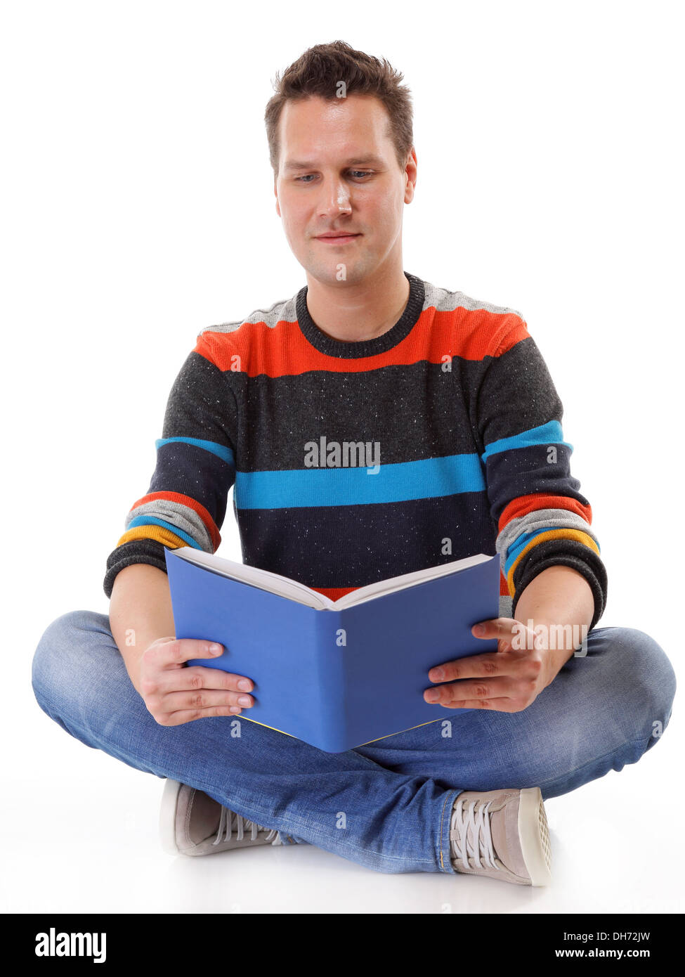 Young man student sitting and reading blue book. Isolated on white ...