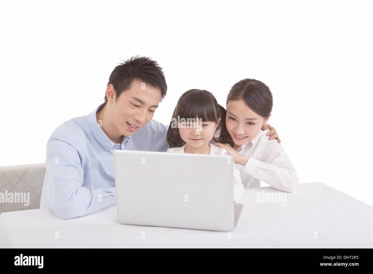 A family of three looking at the computer Stock Photo - Alamy