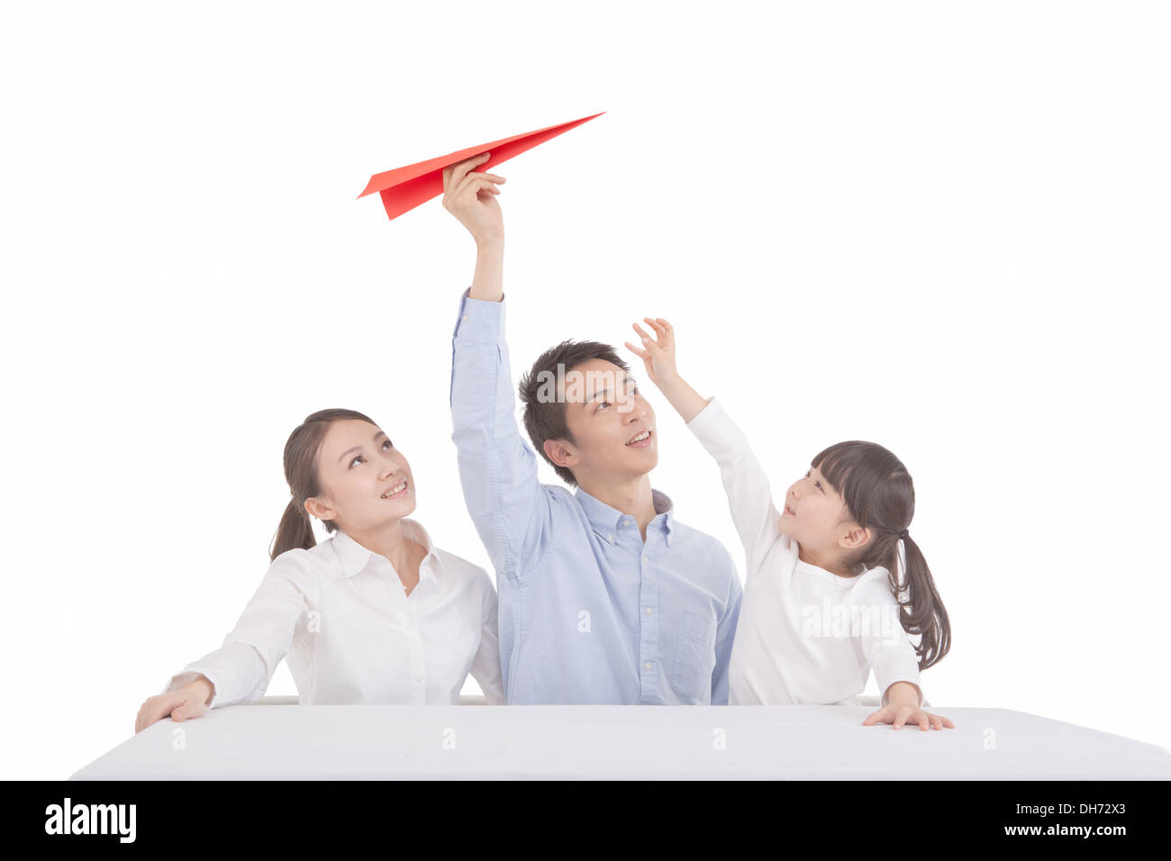 A family of three playing paper airplane Stock Photo - Alamy