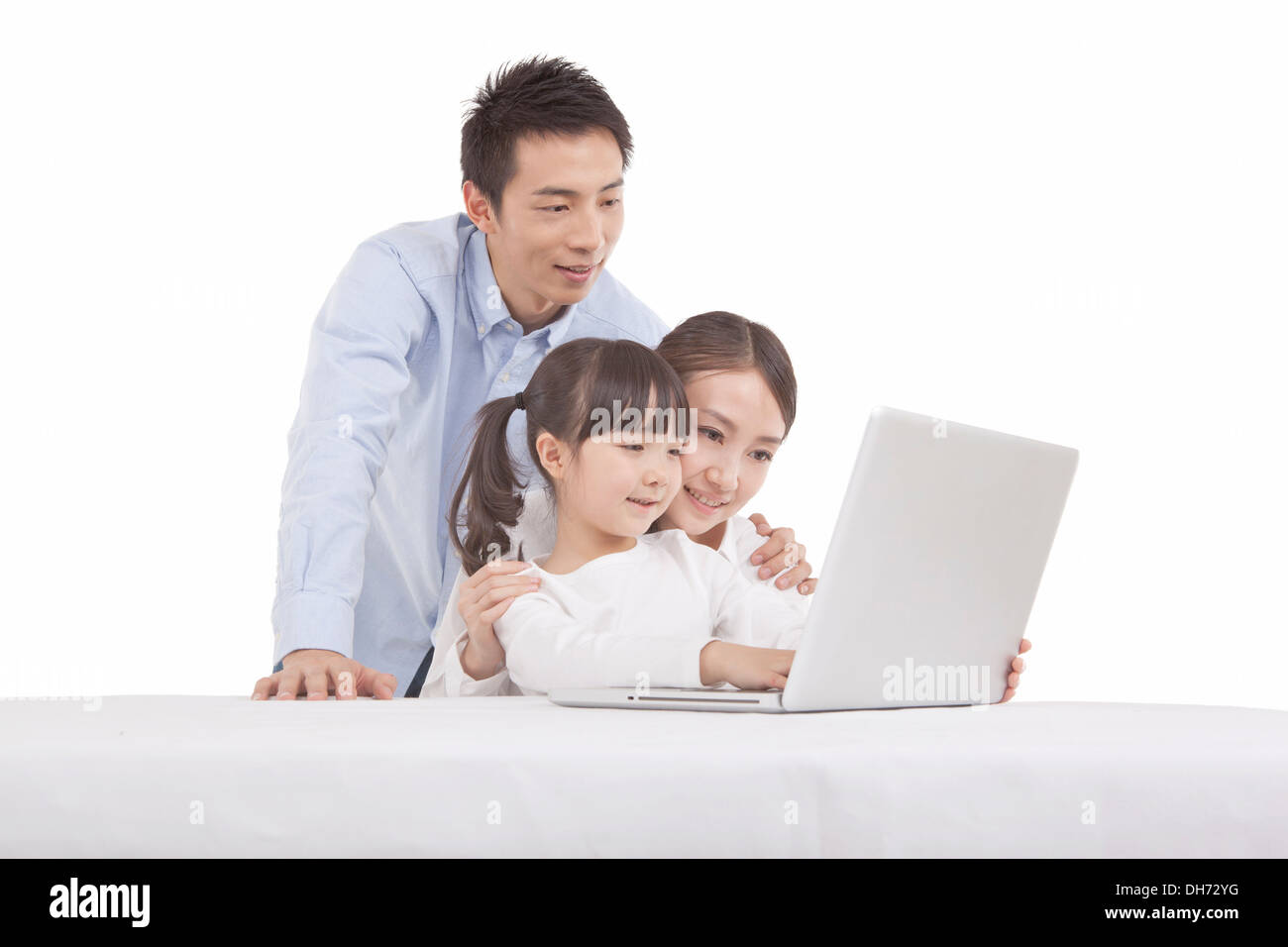 A family of three looking at the computer Stock Photo - Alamy