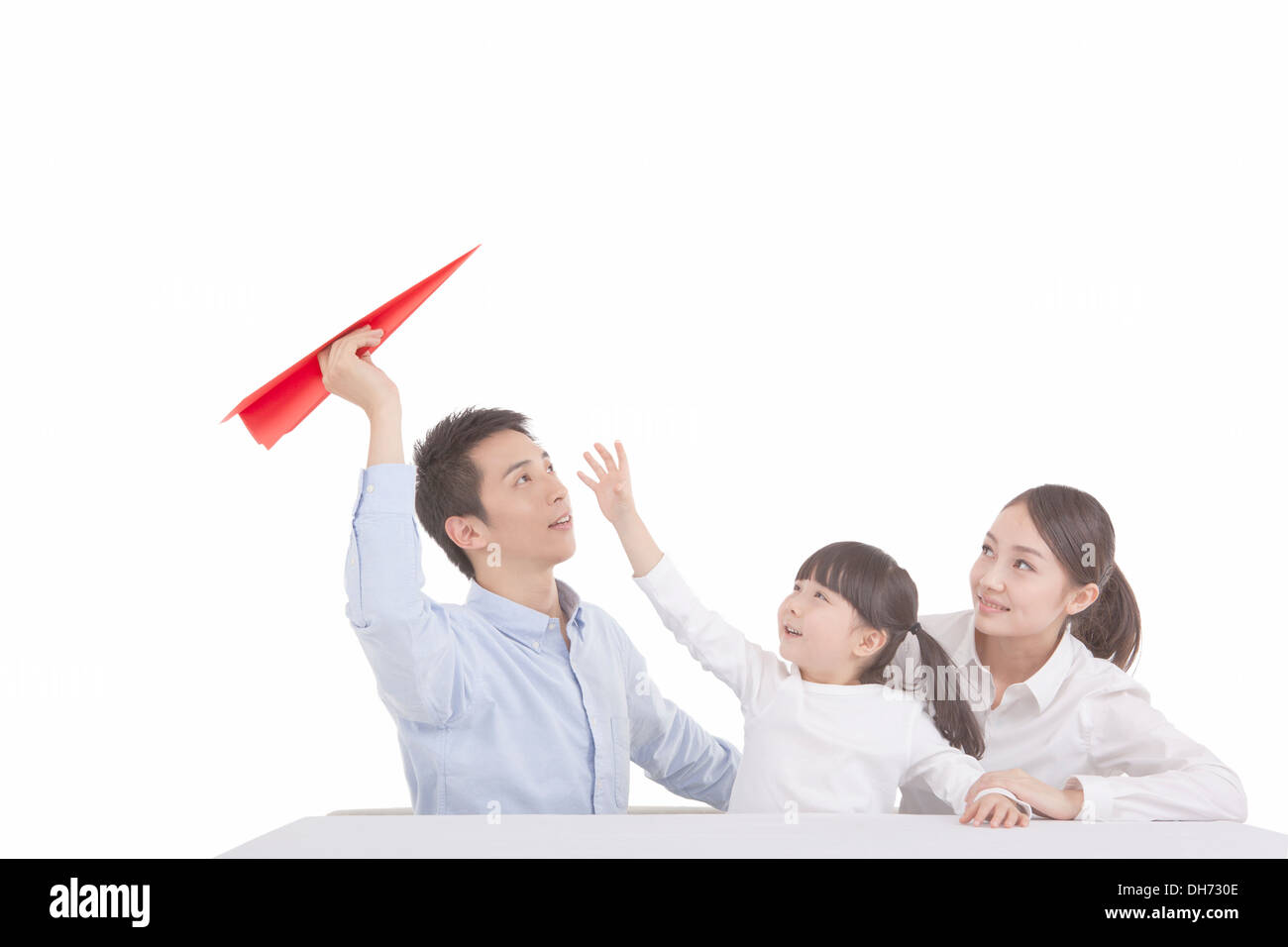 A family of three playing paper airplane Stock Photo - Alamy