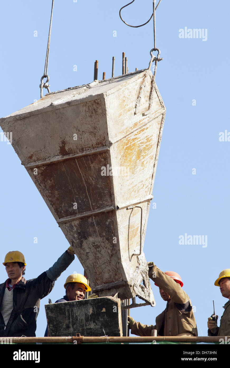 Builders using a crane to load cement on a construction site in Beijing ...