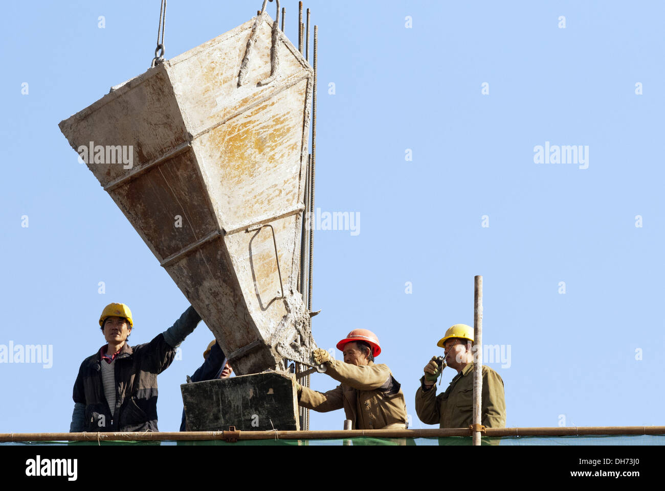 Builders using a crane to load cement on a construction site in Beijing ...