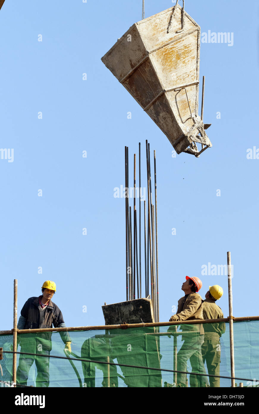 Builders using a crane to load cement on a construction site in Beijing ...