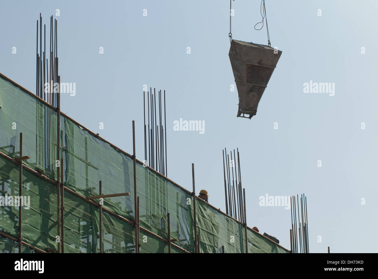 Builders using a crane to load cement on a construction site in Beijing ...