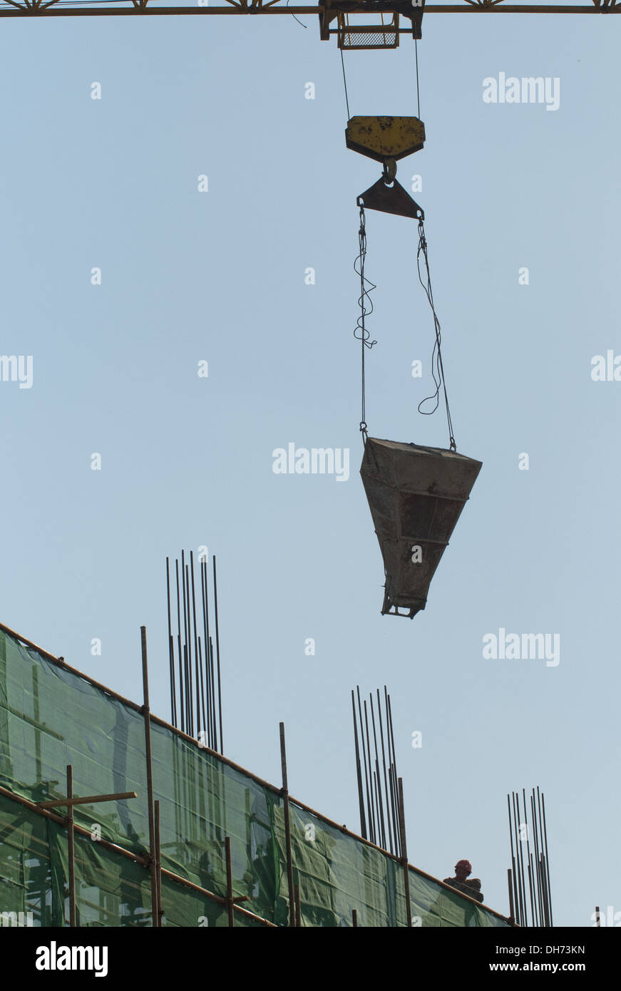 Builders using a crane to load cement on a construction site in Beijing ...
