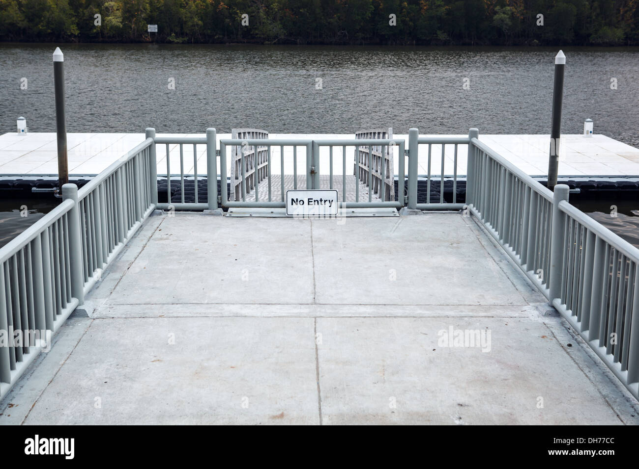 Gray metal fence with a sign to protect the pier Stock Photo - Alamy