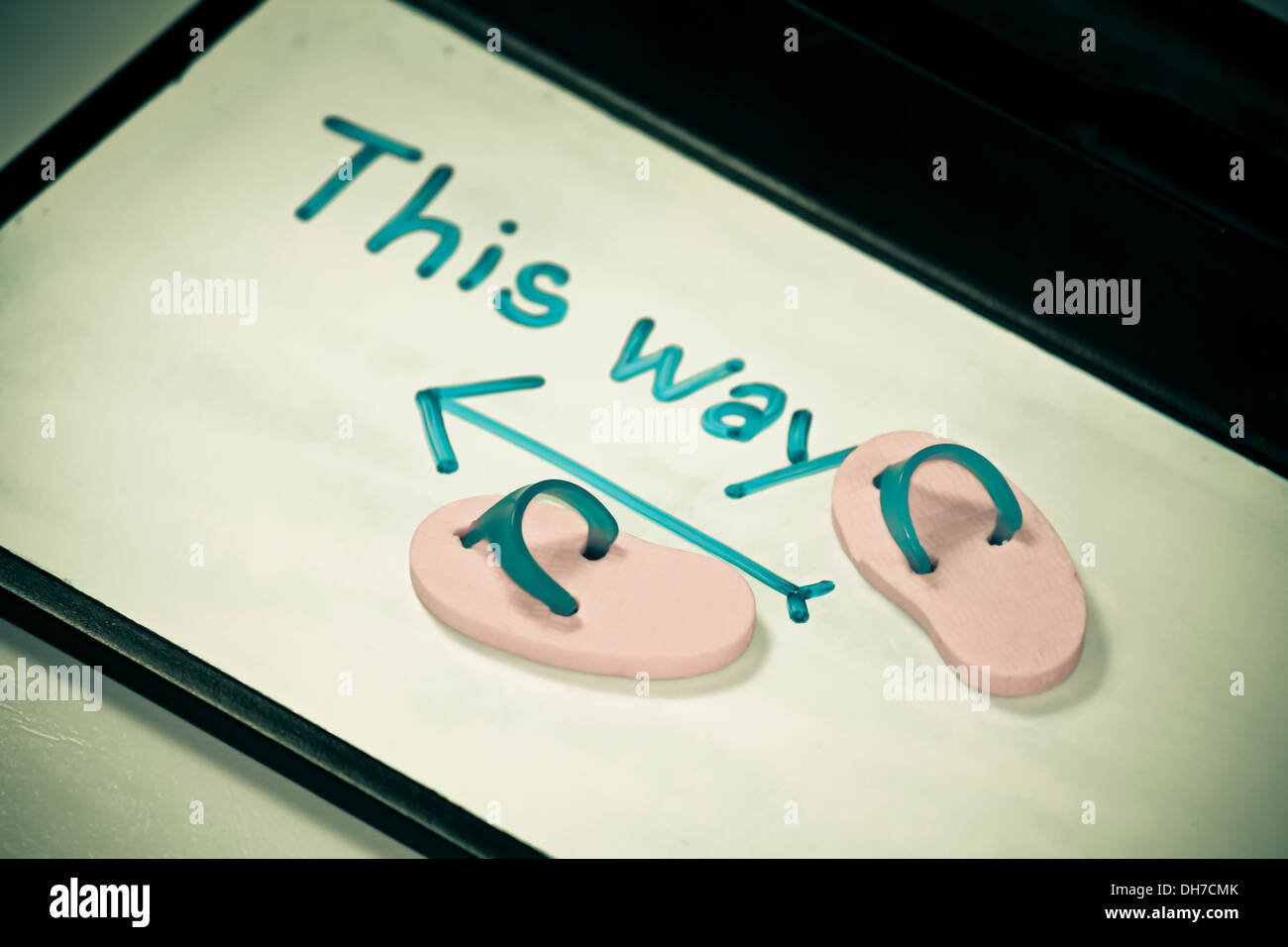 Miniature rubber slippers with wording This way, Concept Stock Photo ...