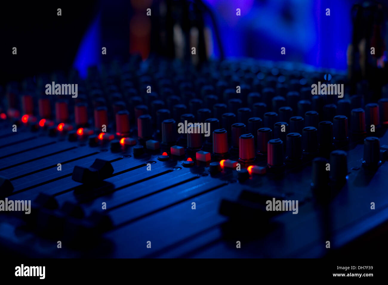 Close up view at night of the volume and mixing sliders on a DJ music ...