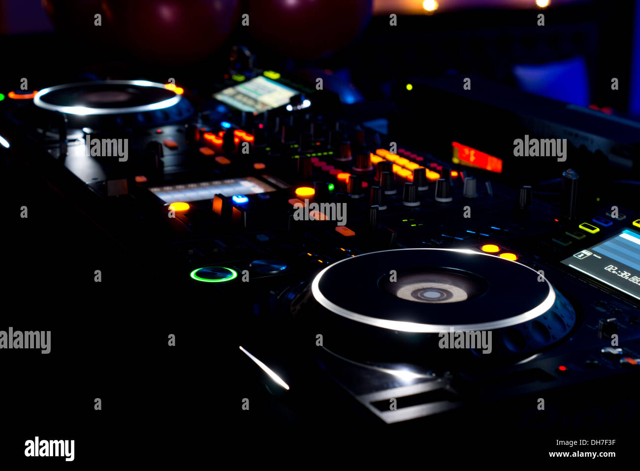 Close up view at night of the colourful lights on a DJ music deck ...