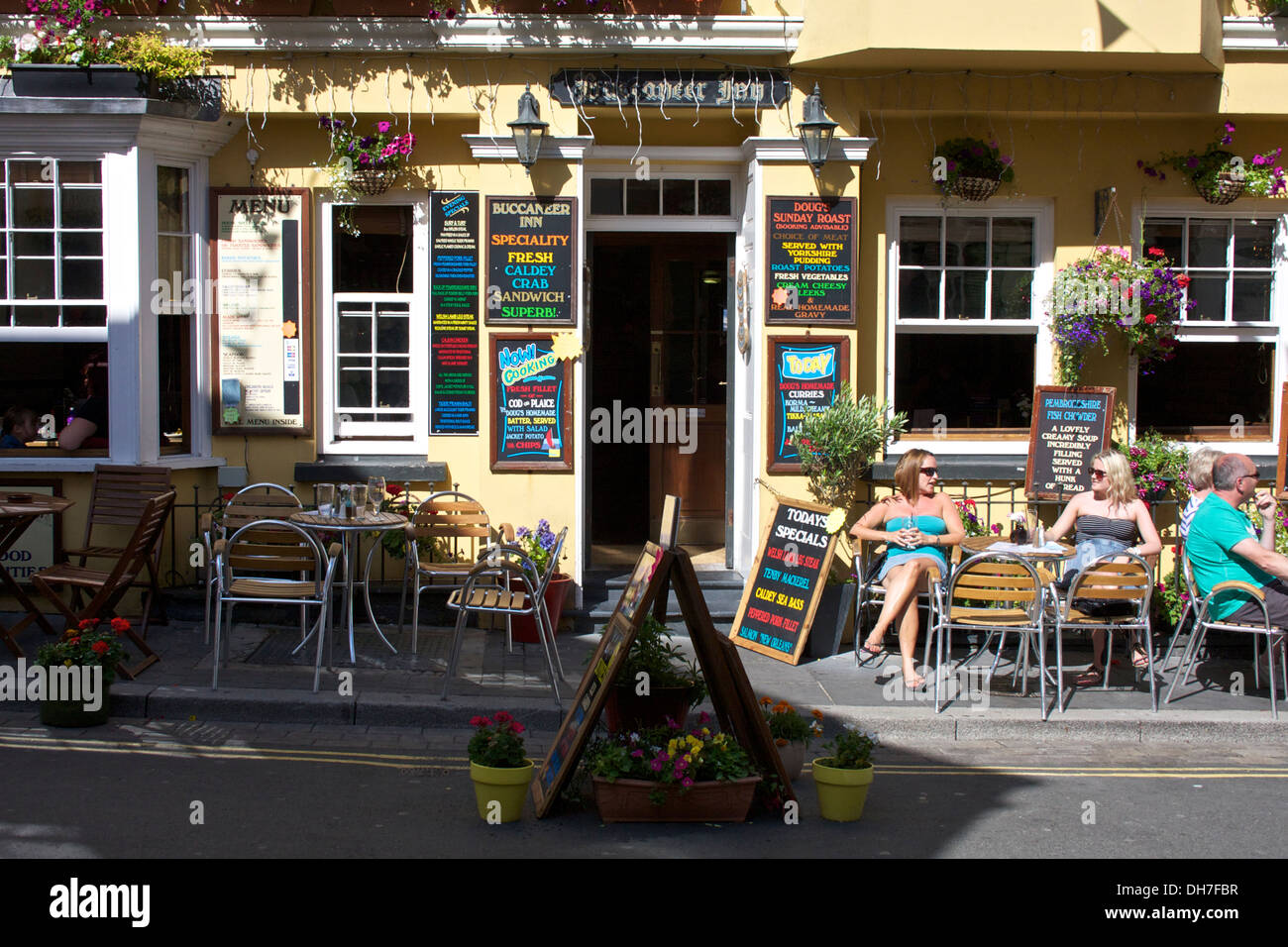 Two women sat outside a pub in late afternoon sunlight Stock Photo - Alamy