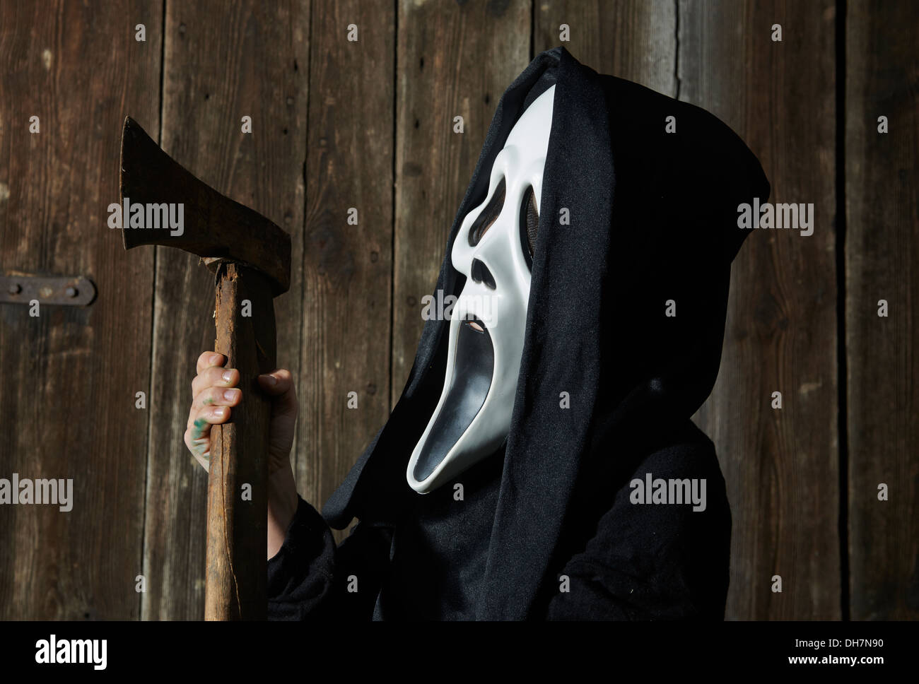 Man in scary "scream" mask holds axe. Mask of grim reaper. Carnival ...