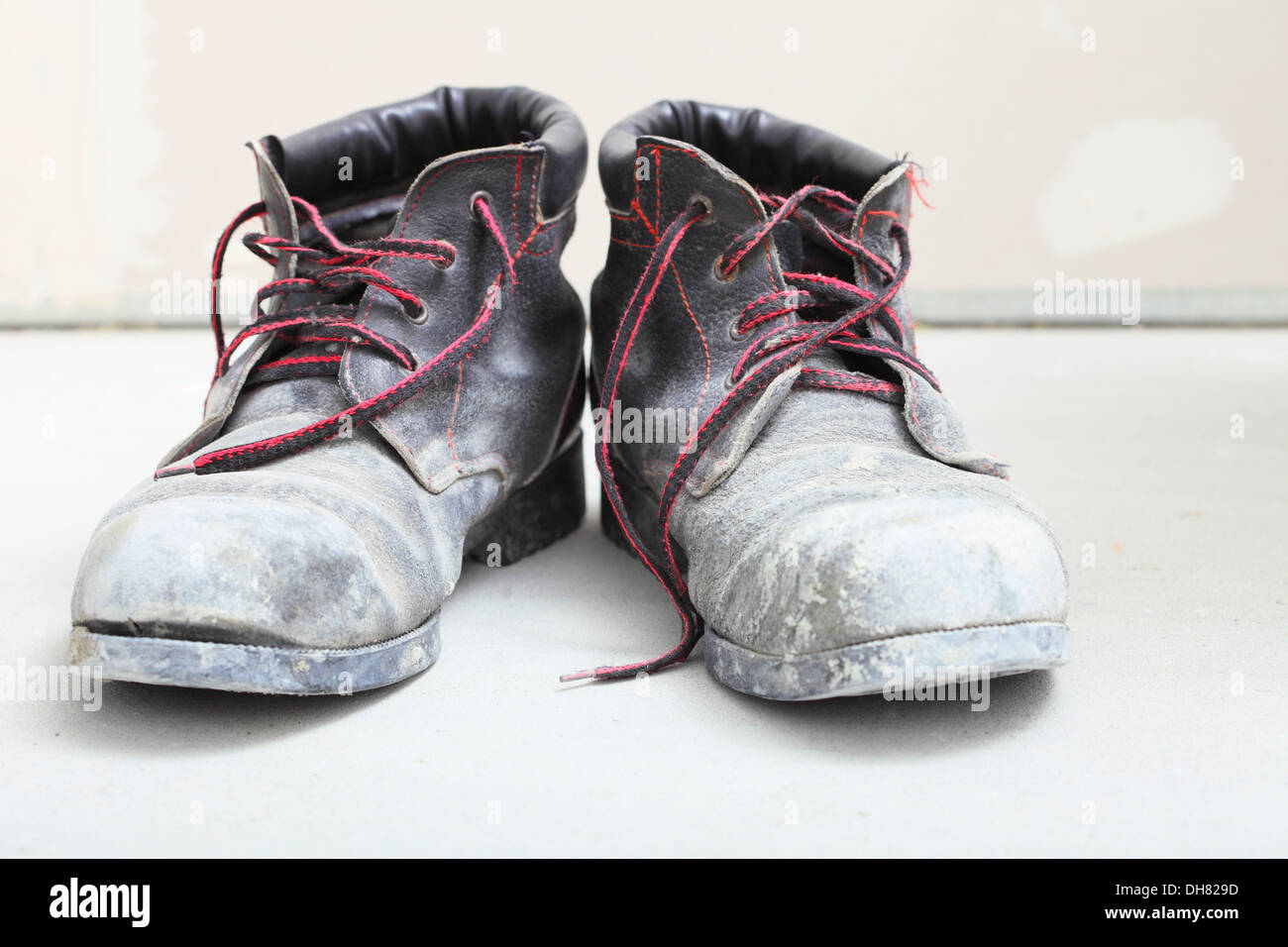 pair of old dirty work boots in construction site Stock Photo - Alamy