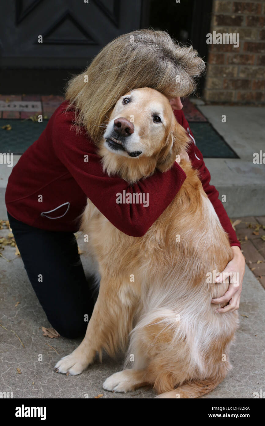 A woman hugging an old Golden Retriever dog Stock Photo - Alamy
