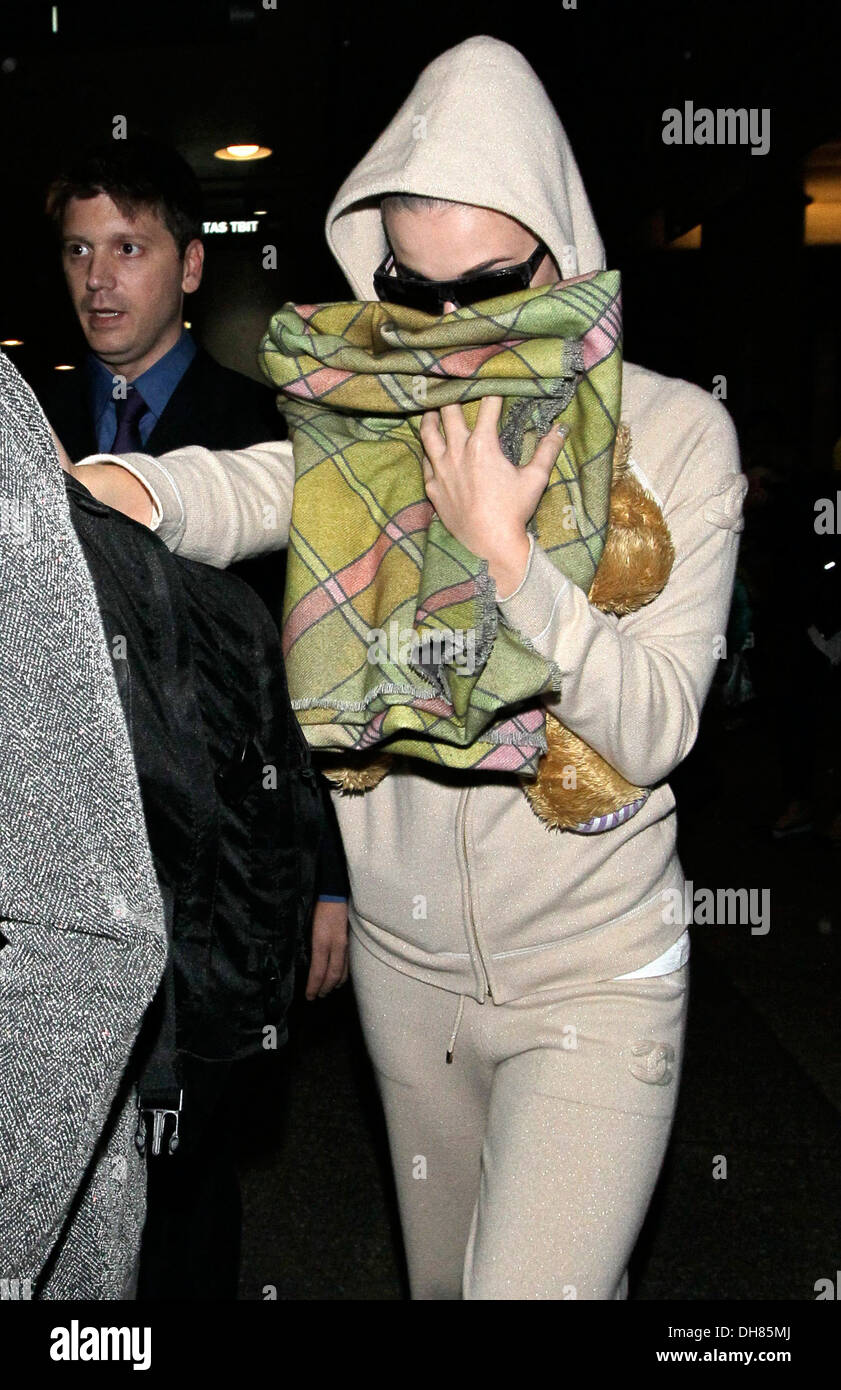 Katy Perry clings to her assistant and covers her face with a blanket ...