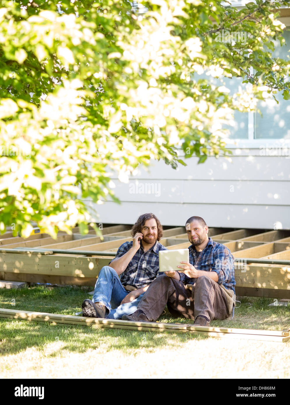 Workers Using Digital Tablet And Mobile Phone At Construction Si Stock ...