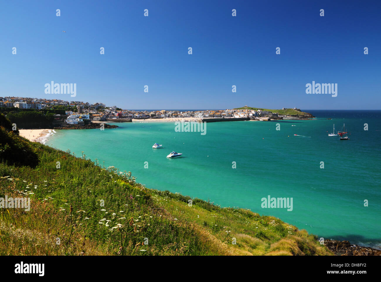 A wide bay with turquoise blue water, a beach and a harbour in the ...