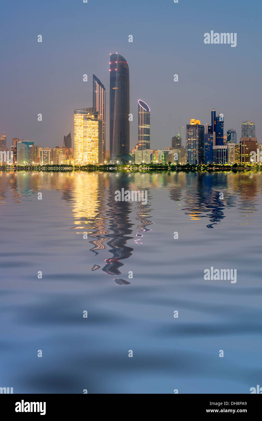 Evening view of skyline and refection of high rise towers Abu Dhabi in ...