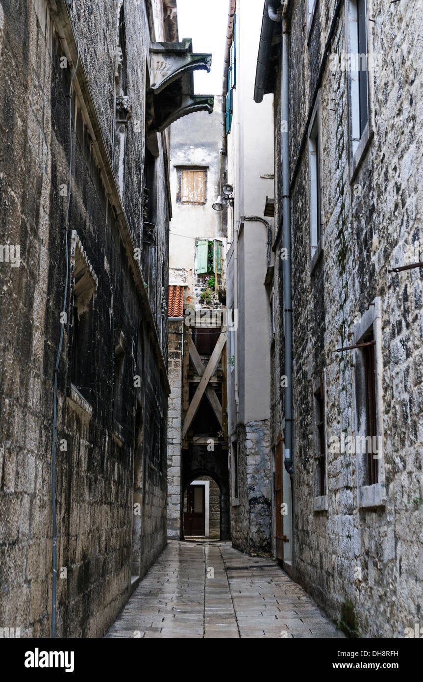 One of many ancient marble footpaths between tall buildings leading to ...