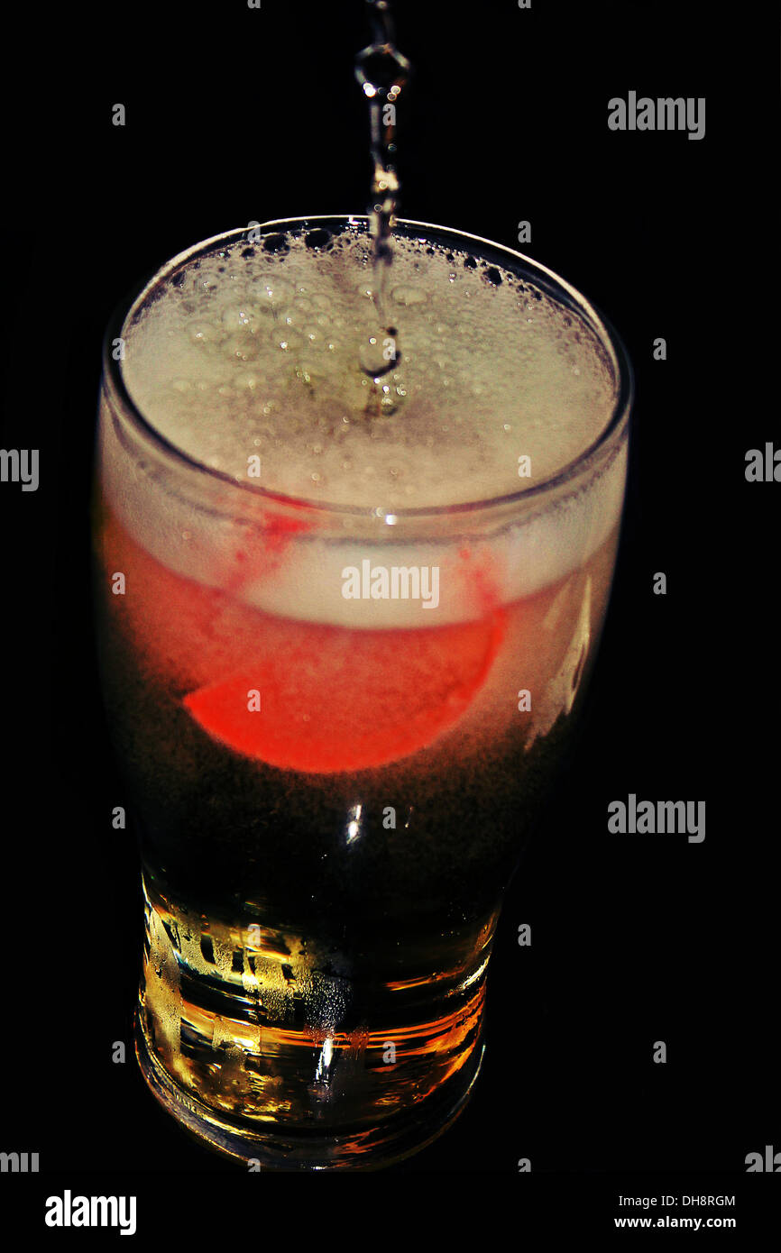 Alcohol dripping into a glass with ice and bubbles Stock Photo - Alamy
