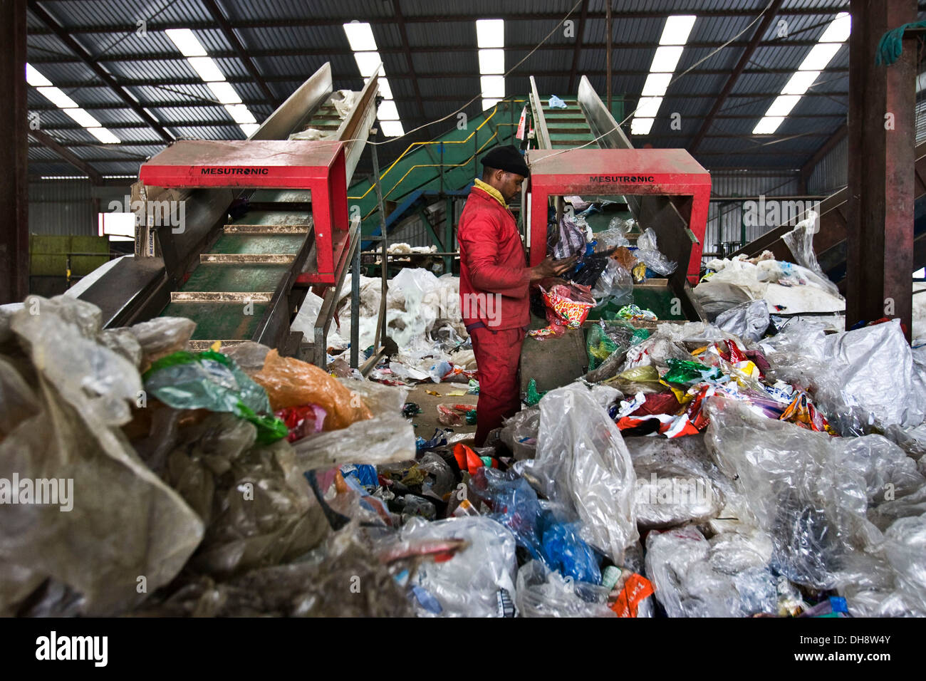 A worker at the waste processing site helps to sort through all of the ...