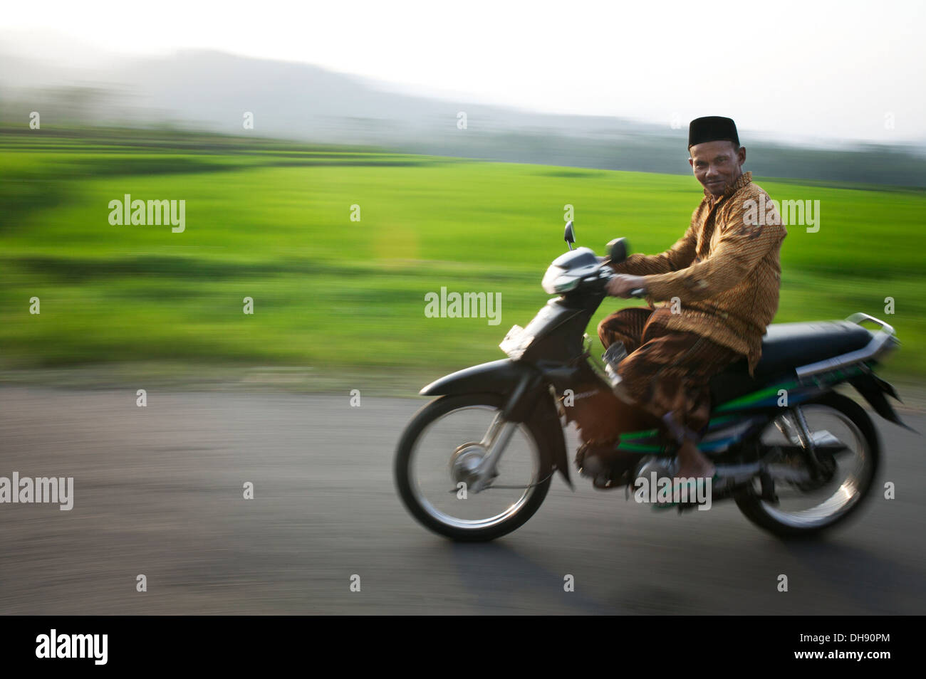 Man Riding By On A Motor Scooter; Java, Indonesia Stock Photo - Alamy