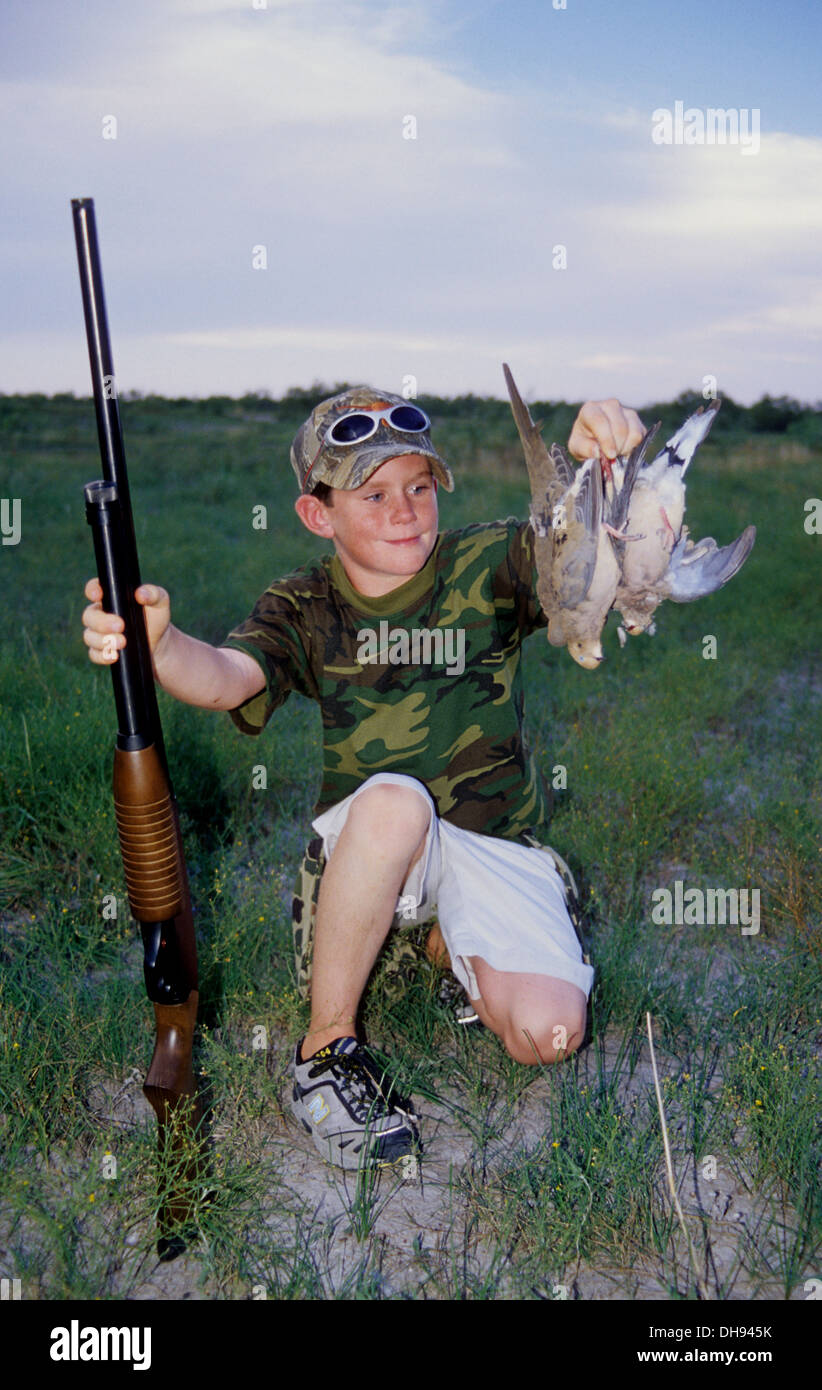 A young boy with doves and a his shotgun on a dove hunting trip near ...