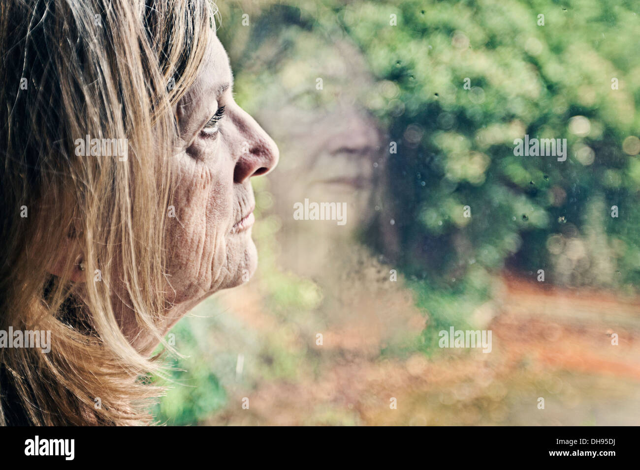 Senior Lady looking out of Window Stock Photo - Alamy