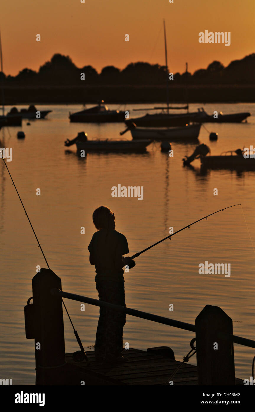 A boy fishing in the evening sunlight Stock Photo - Alamy