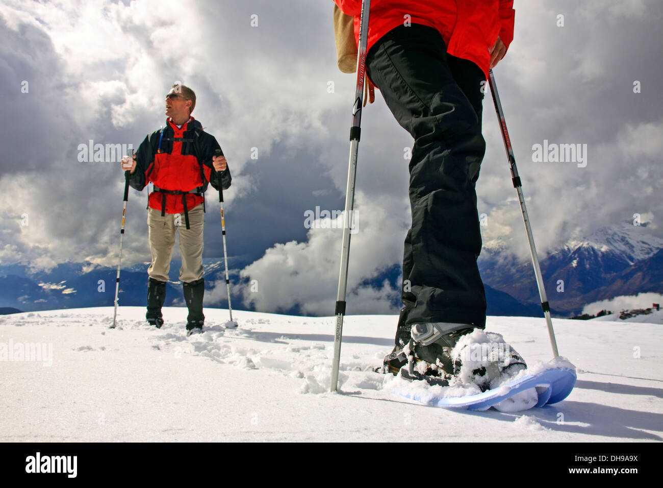 Mountain walkers wearing snowshoes while snowshoeing in deep powder ...