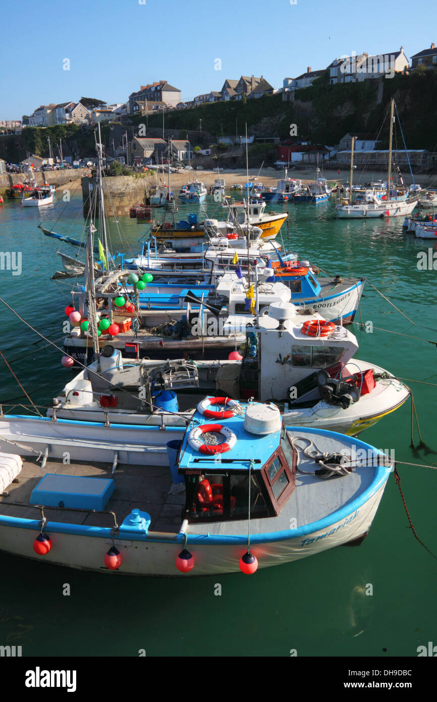 Fishing boats in a harbour with cliffs and buildings Stock Photo - Alamy
