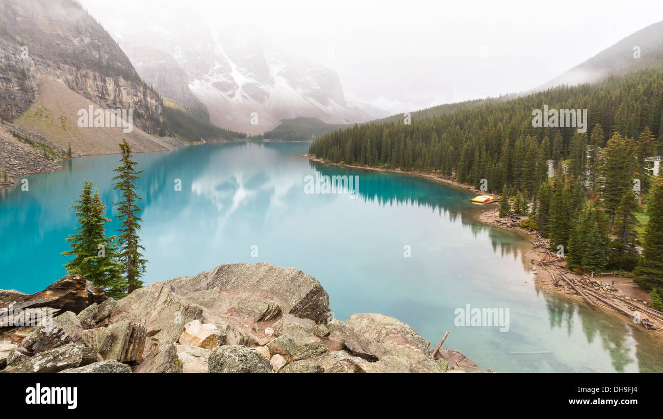 The Valley on the Ten Peaks shrouded in fog seen from the rockpile on glacier-fed Moraine Lake ...