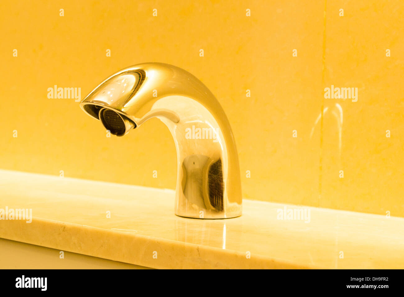 Marble sink faucet with golden light Stock Photo - Alamy