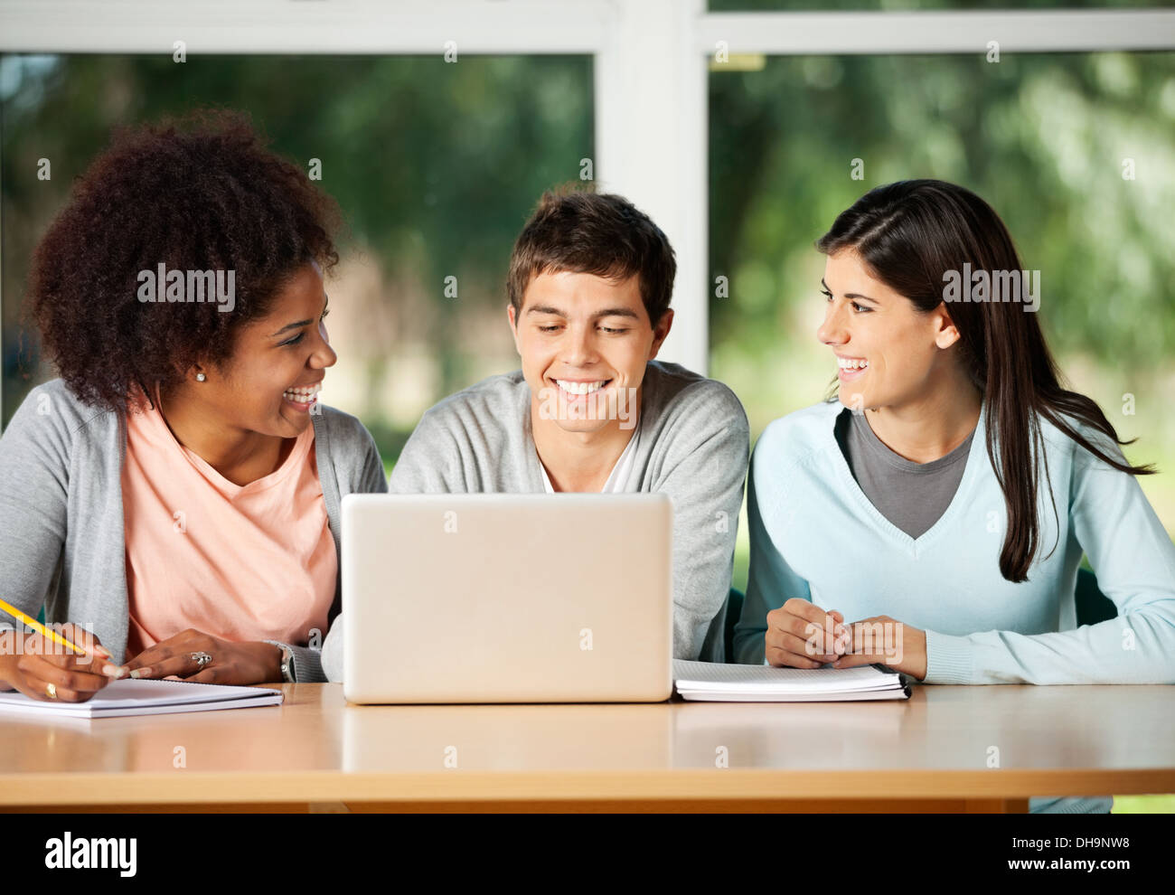Happy Friends With Laptop Sitting In Classroom Stock Photo - Alamy