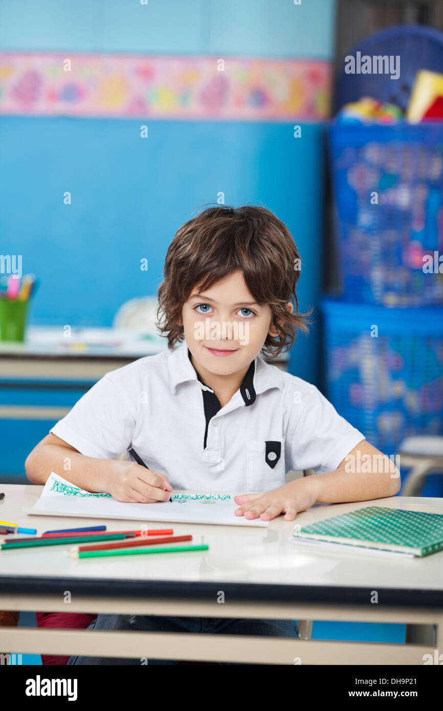 Boy With Sketch Pen Drawing In Classroom Stock Photo - Alamy