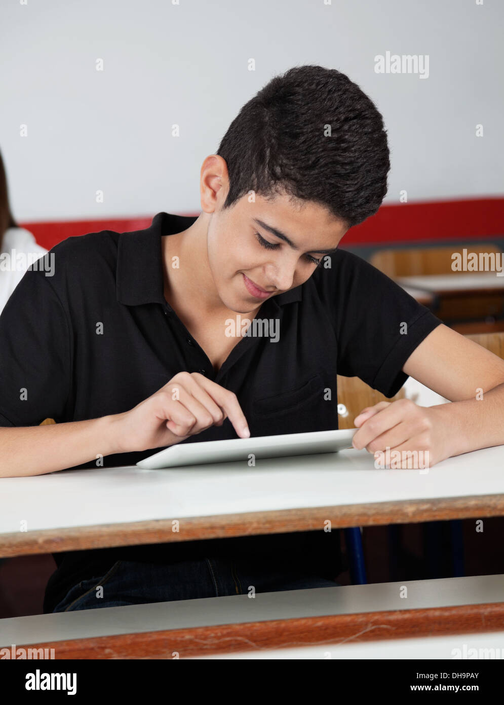 Happy Teenage Schoolboy Using Tablet At Desk Stock Photo - Alamy
