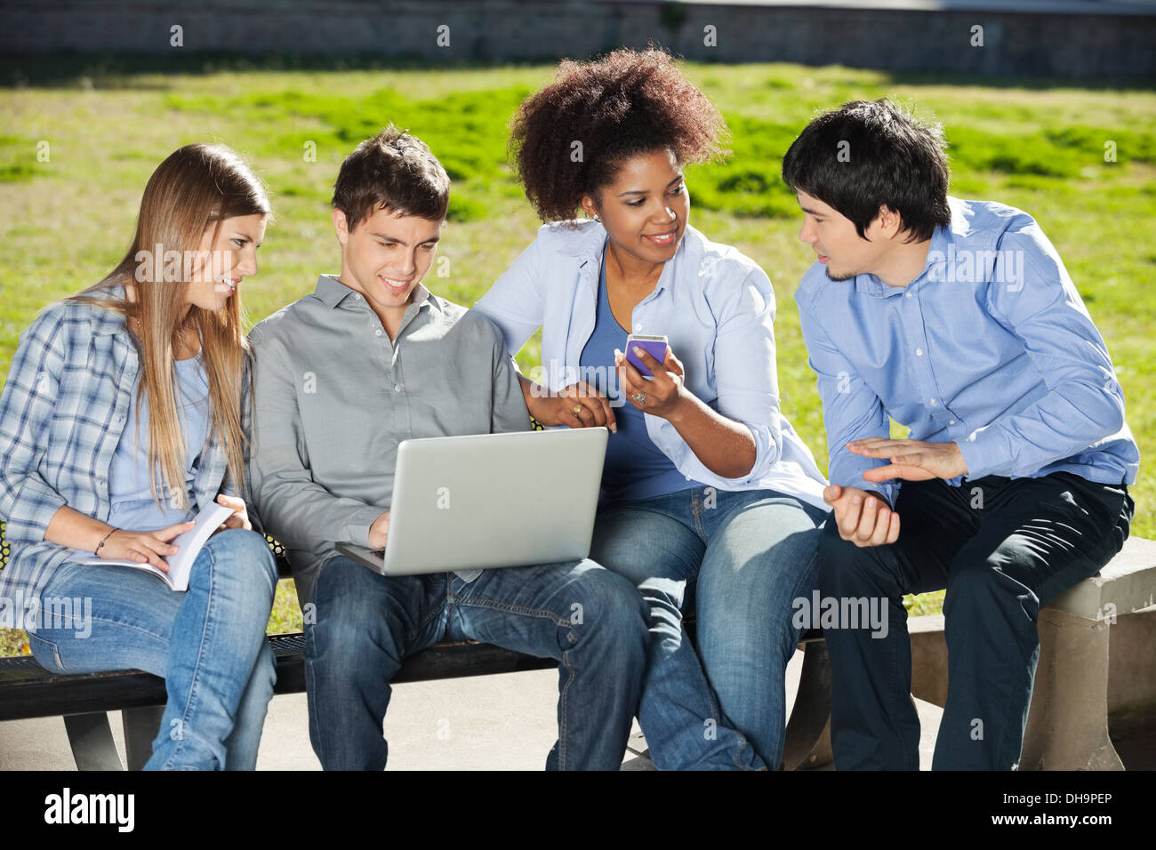 Students With Laptop And Mobilephone Sitting In Campus Stock Photo - Alamy