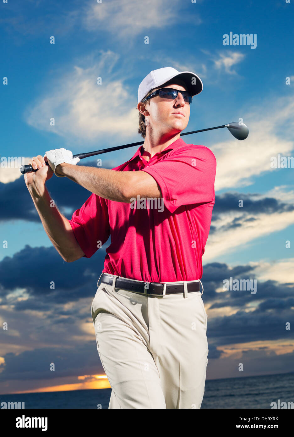 Golfer at sunset, Man swinging golf club with dramatic sunset sky ...