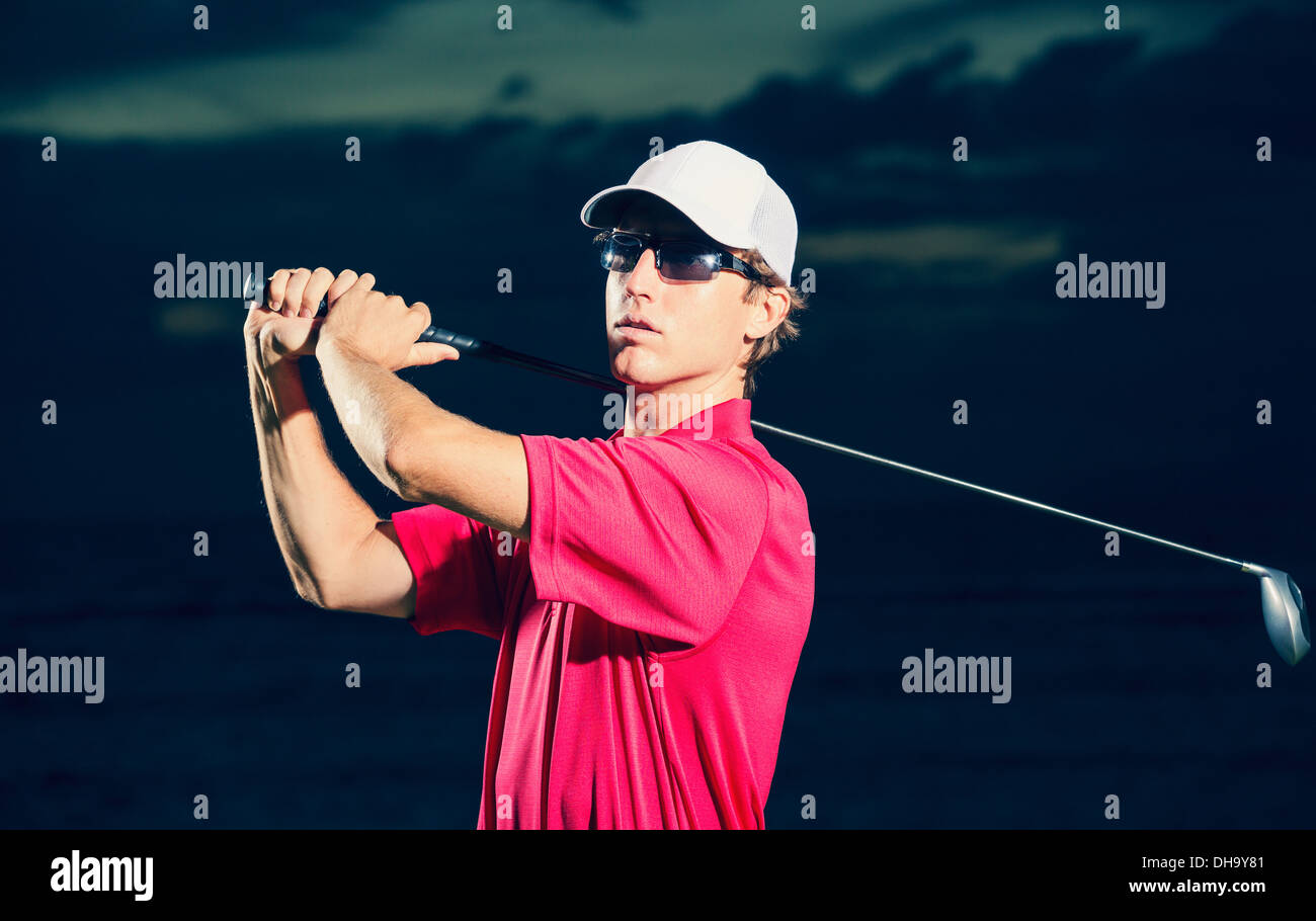 Golfer at sunset, Man swinging golf club with dramatic sunset sky ...