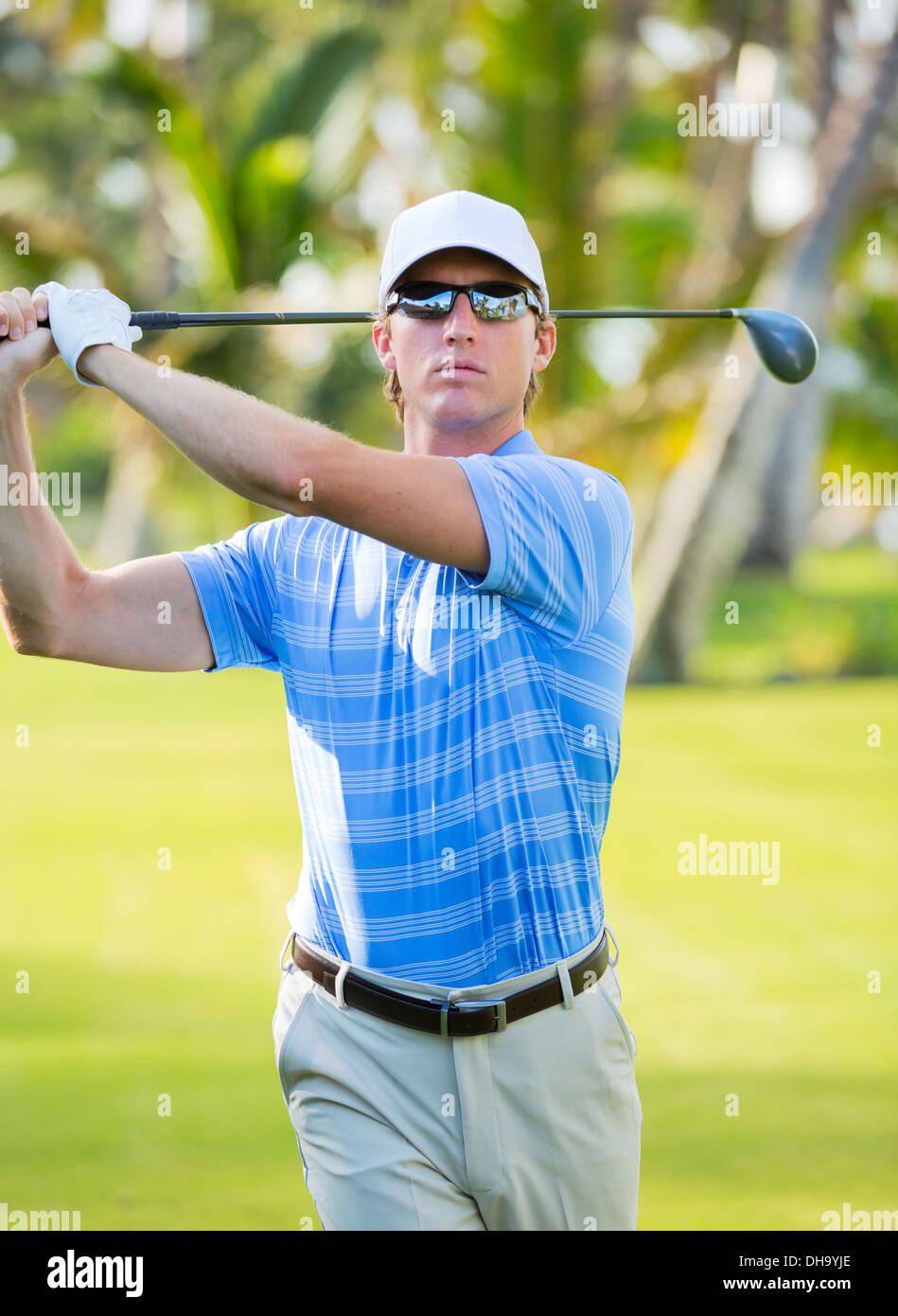 Athletic young man playing golf, golfer hitting fairway shot, swinging ...