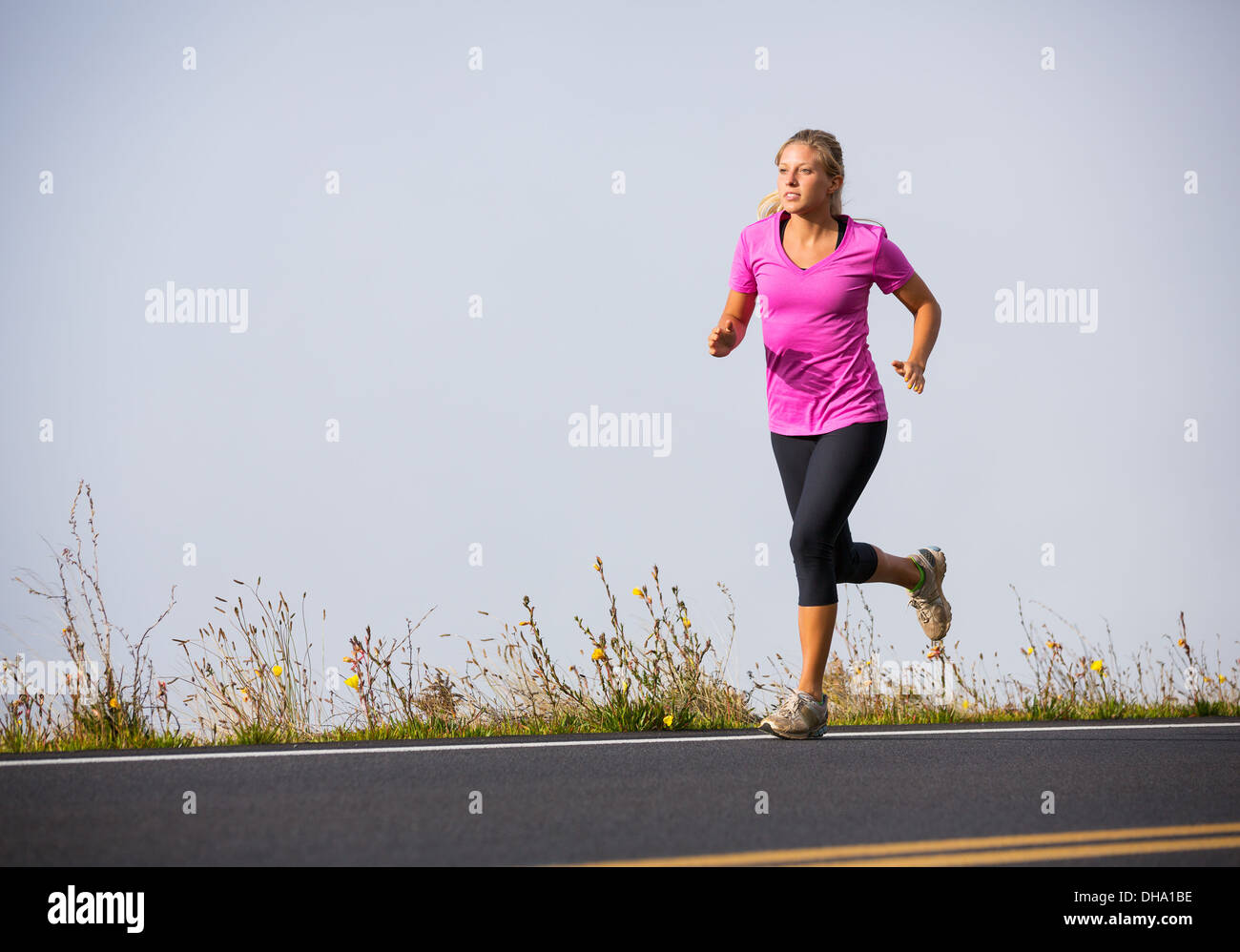 Athletic woman jogging outside, training outdoors. Running on road at ...