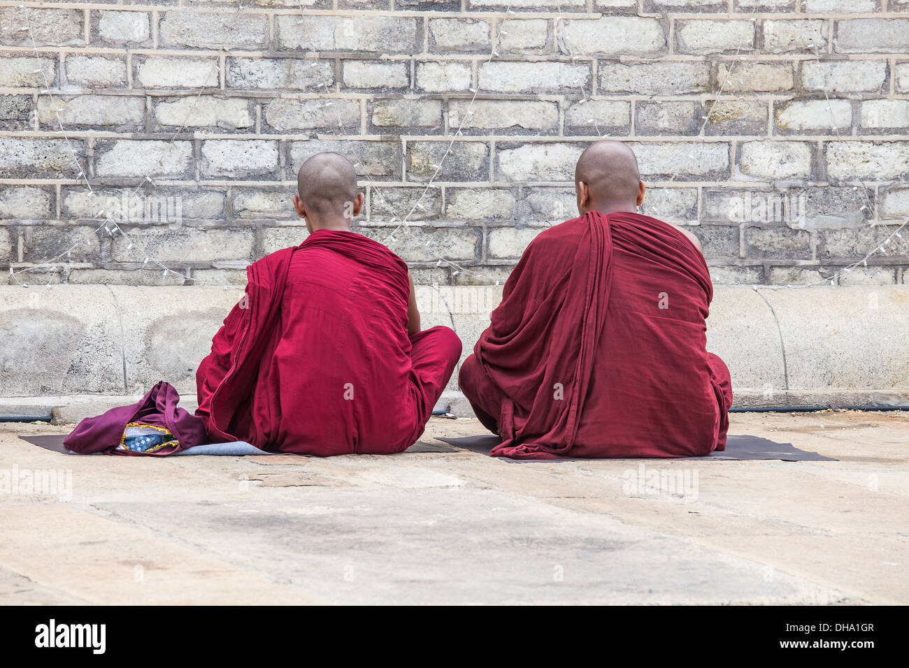 Two buddhist monks in red robes praying Stock Photo - Alamy
