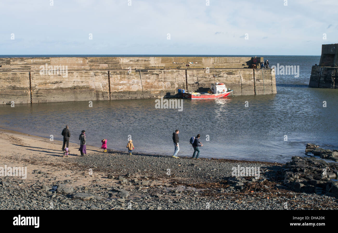 Family playing within Craster harbour, Northumberland, England, UK ...