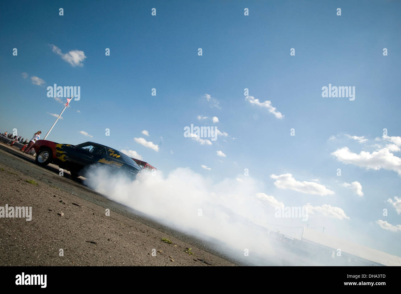 muscle car cars doing a burnout at a dragstrip spinning the wheels ...